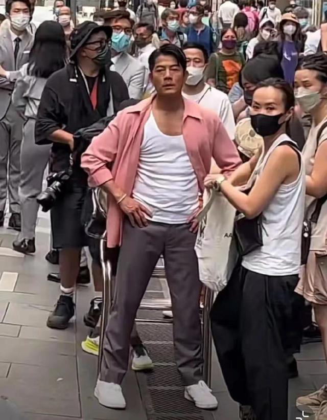 Aaron Kwok was surrounded by onlookers dancing on the street. The 56-year-old wore a pink shirt ...